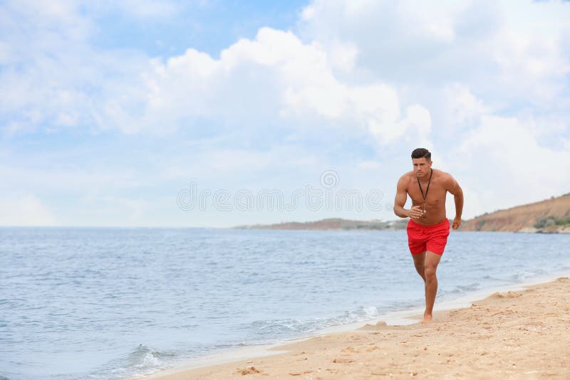 Handsome Male Lifeguard Running on Sandy Beach Stock Photo - Image of ...