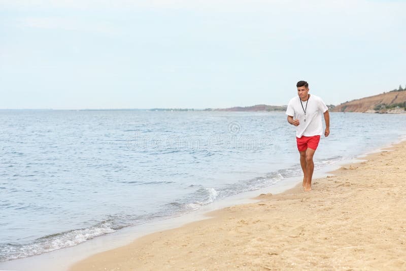 Handsome Male Lifeguard Running on Sandy Beach Stock Photo - Image of ...