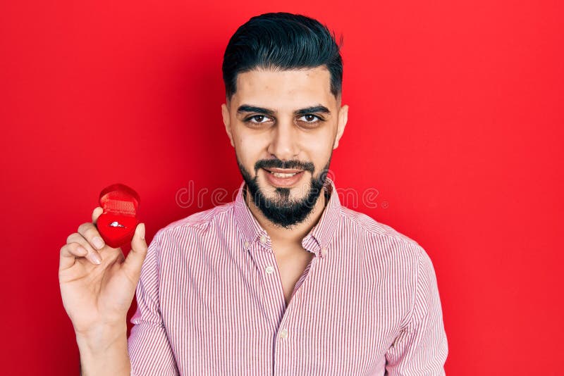 Handsome Man With Beard Holding Engagement Ring For Proposal Looking