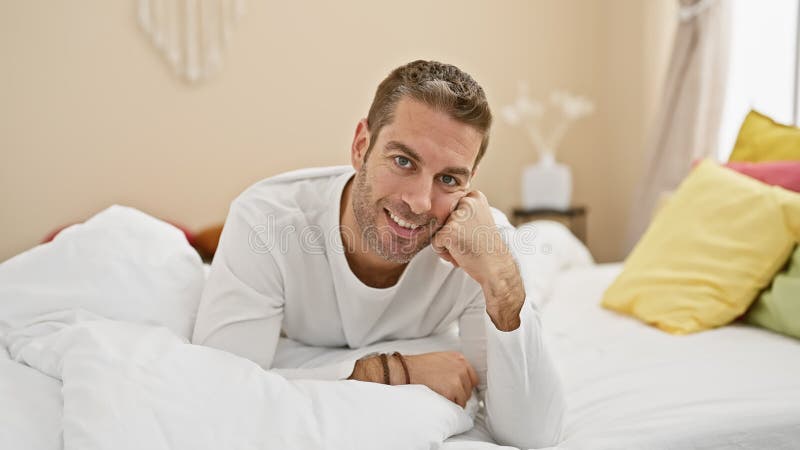 Handsome Man with a Beard Lying in Bed, Smiling in a Relaxed Bedroom ...