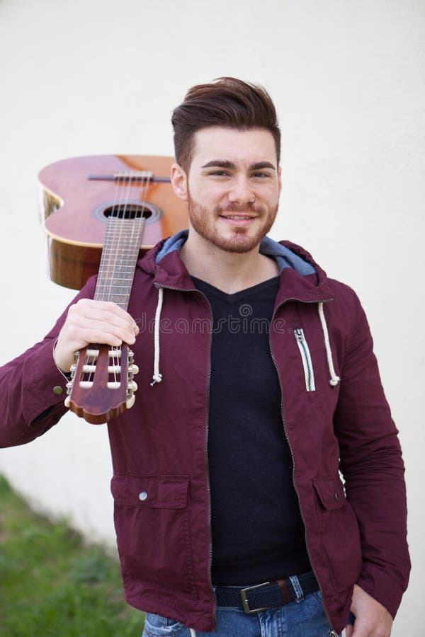 Handsome Man Carrying a Guitar on His Shoulders Stock Photo - Image of ...