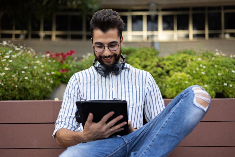 Handsome Man Checking His Tablet Sitting on a Bench Stock Image - Image ...
