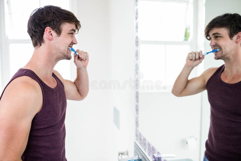 Handsome Man Cleaning His Teeth Stock Photo - Image of indoors ...