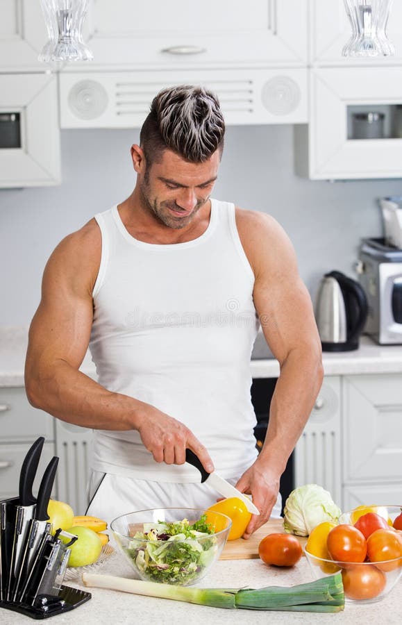Handsome Man Cooking at Home Preparing Salad in Kitchen. Stock Photo ...