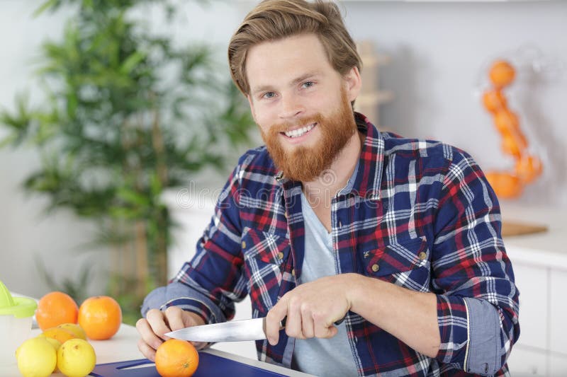 Handsome Man Cutting Orange by Knife on Kitchen Stock Image - Image of ...