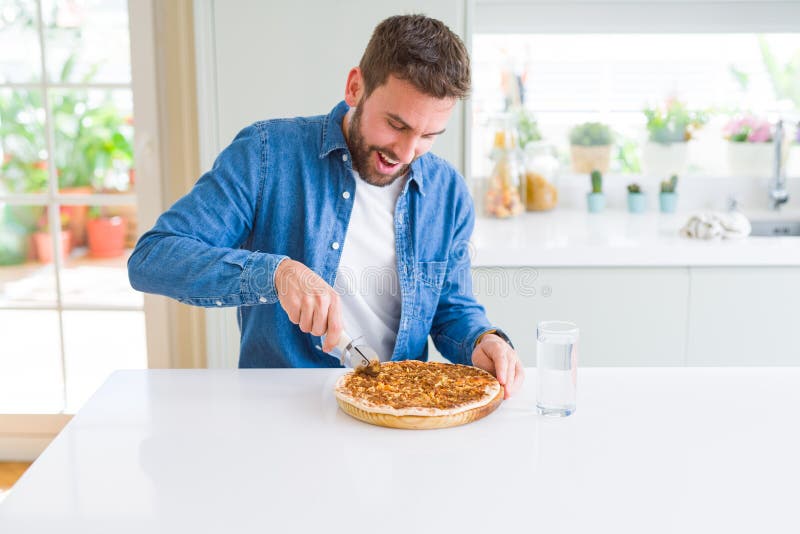 Handsome Man Cutting a Pizza Slice at Home Stock Photo - Image of beard ...
