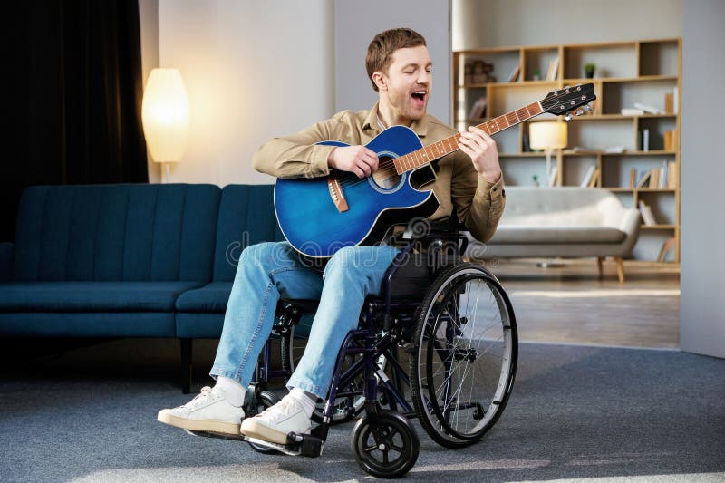 Handsome Man with a Disability Sitting in Wheelchair Playing on Guitar ...