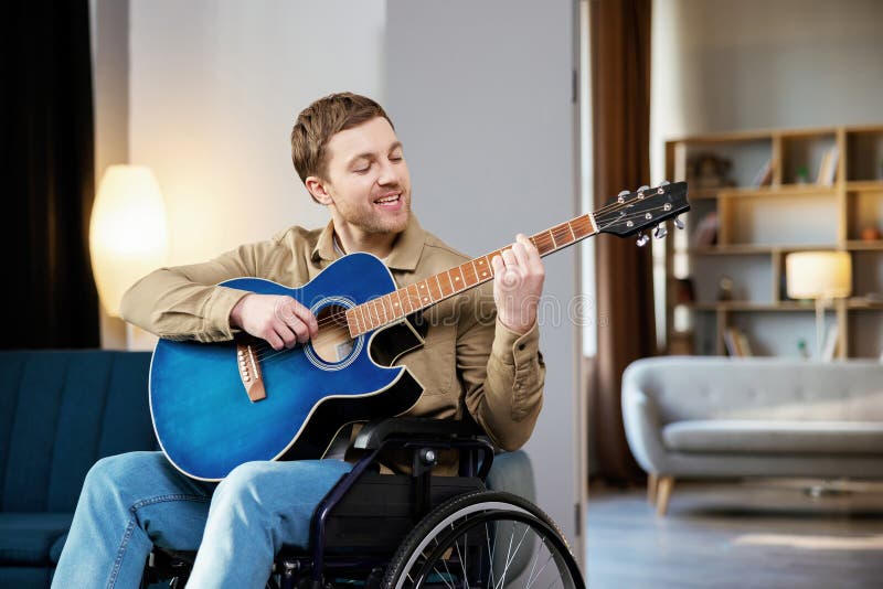Handsome Man with a Disability Sitting in Wheelchair Playing on Guitar ...