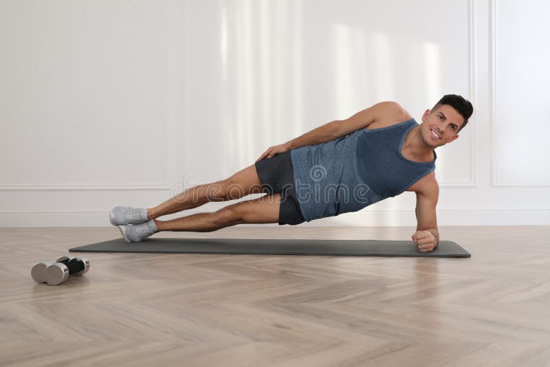 Handsome Man Doing Side Plank Exercise on Yoga Mat Indoors Stock Photo ...