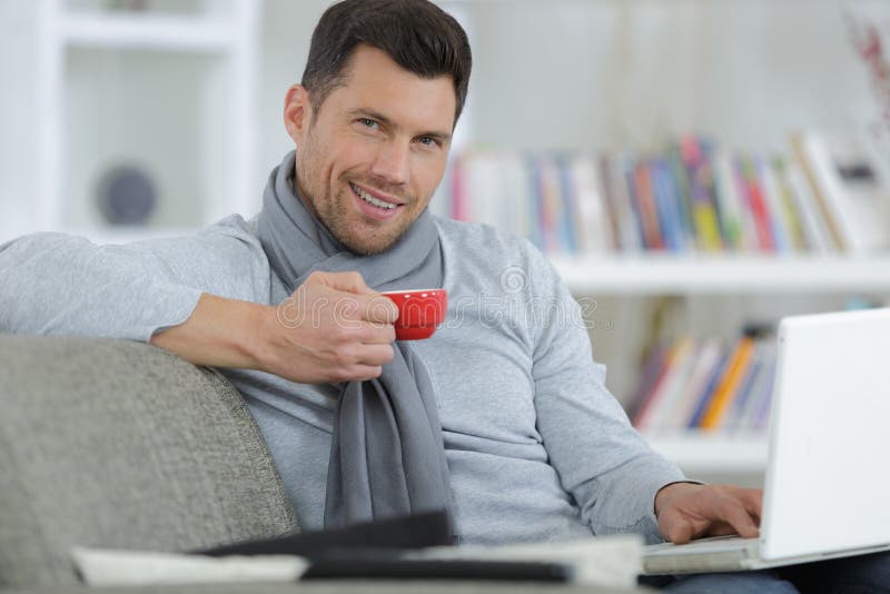 Handsome Man Drinking Coffee while Working with Laptop at Home Stock ...