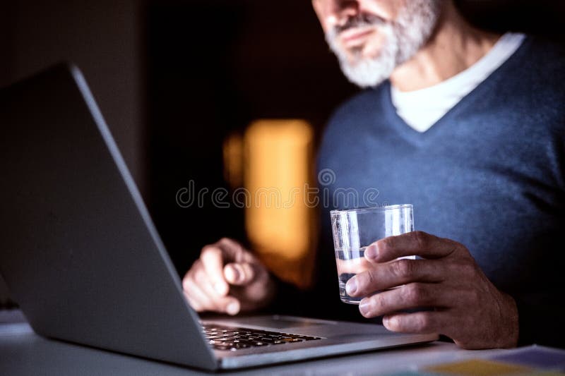 Handsome Man Drinking while Working from Home Office at Evening, Using ...