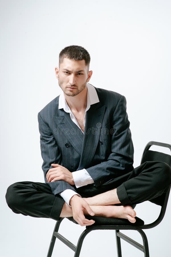Handsome Man, Fashion Model Sits on Chair Barefoot in Studio Stock ...