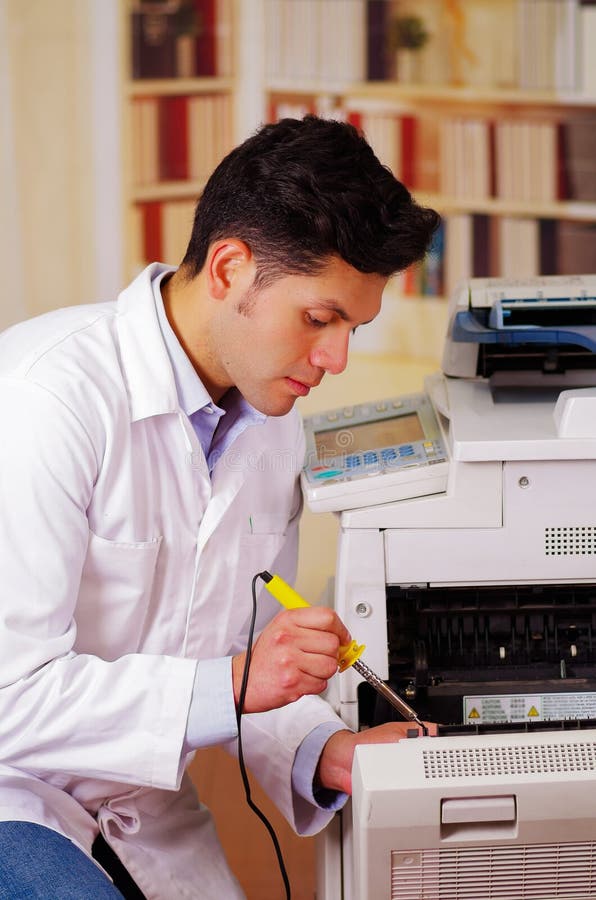 Handsome Man Fixing a Photocopier during Maintenance Using a ...