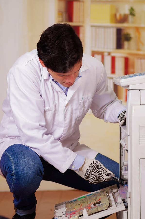 Handsome Man Fixing a Photocopier during Maintenance Using a ...