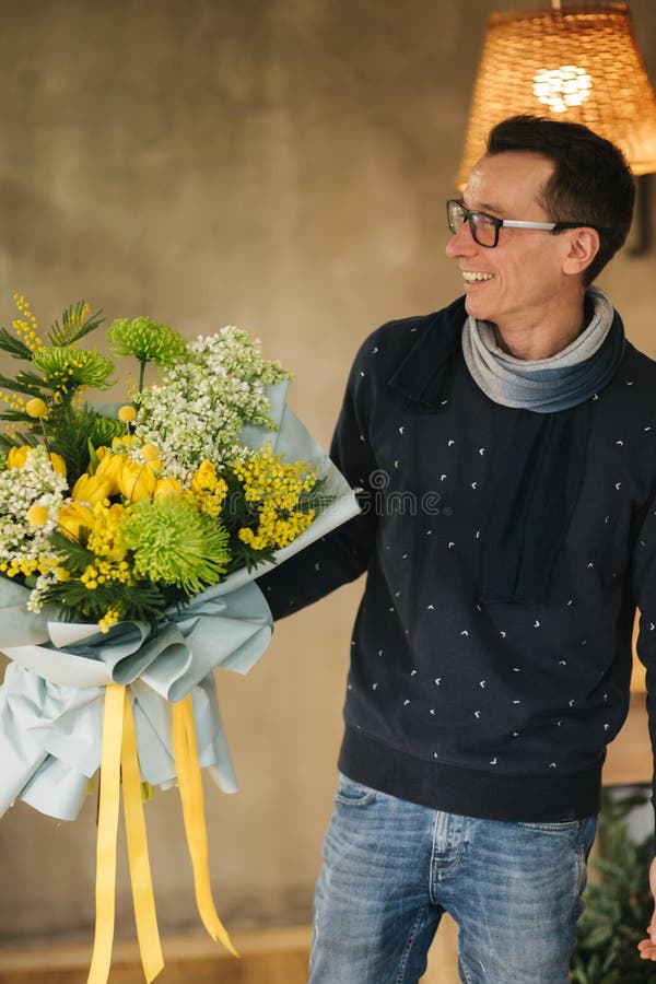Handsome Man in Glasses Hold Spring Bouquet in Hands Inside. Interior ...