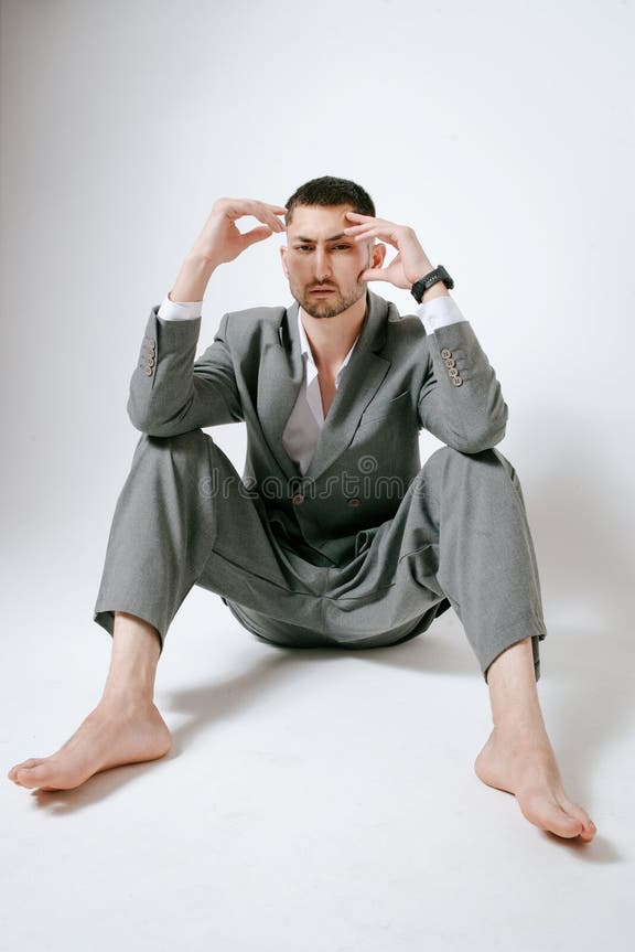 Handsome Man in Grey Suit Sits on the Floor Barefoot. Shoot in Studio ...