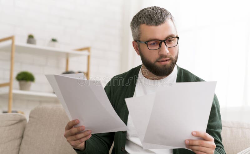 Handsome Man Holding Papers with Both Hands, Reading it Stock Photo ...
