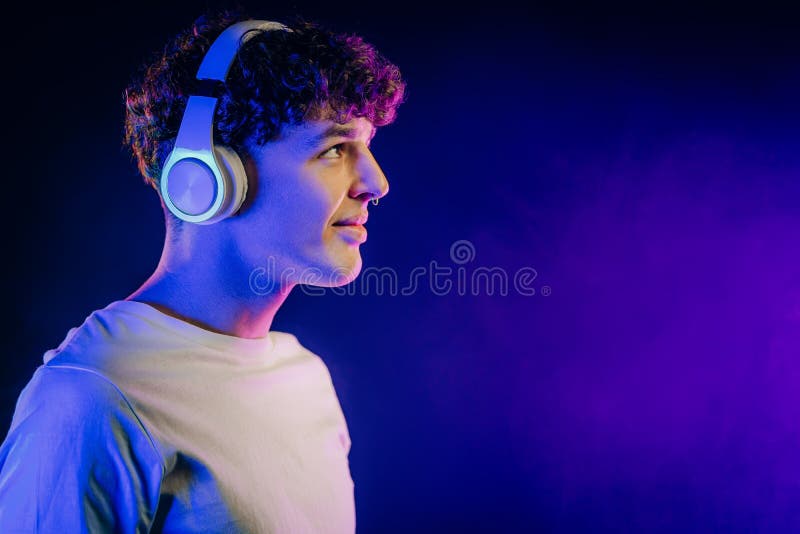 Handsome Man Listening Music With Headphones On Gradient Neon