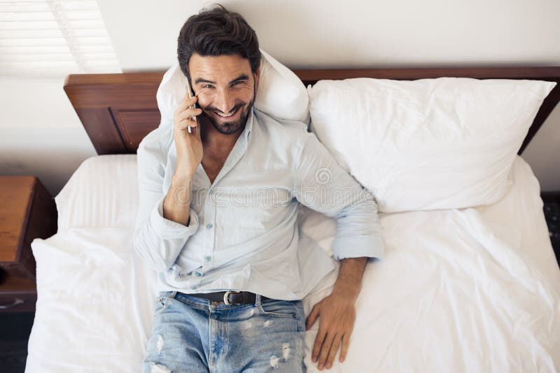 Handsome Man Lying on Bed and Using Smartphone Stock Photo - Image of ...