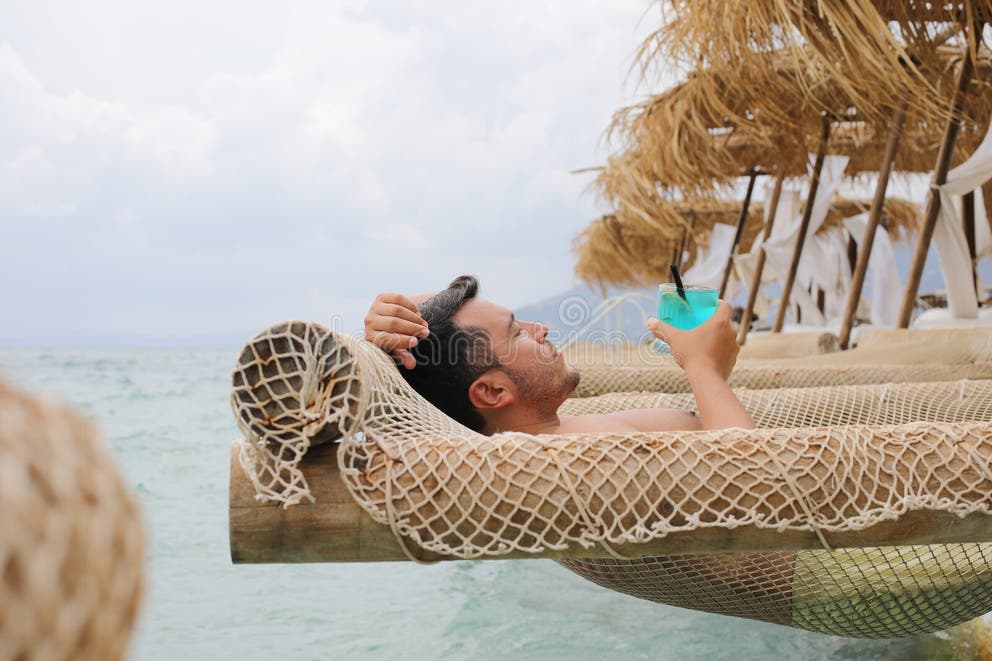 Handsome Man Lying Down on Suspended Net Stock Photo - Image of coast ...
