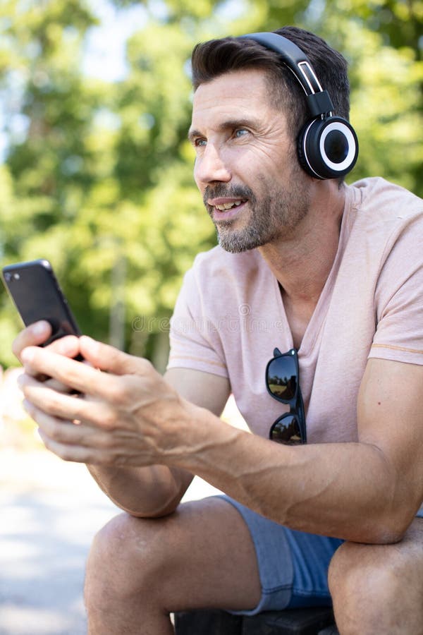 Handsome Man Lying Listening Music Stock Photo - Image of park ...