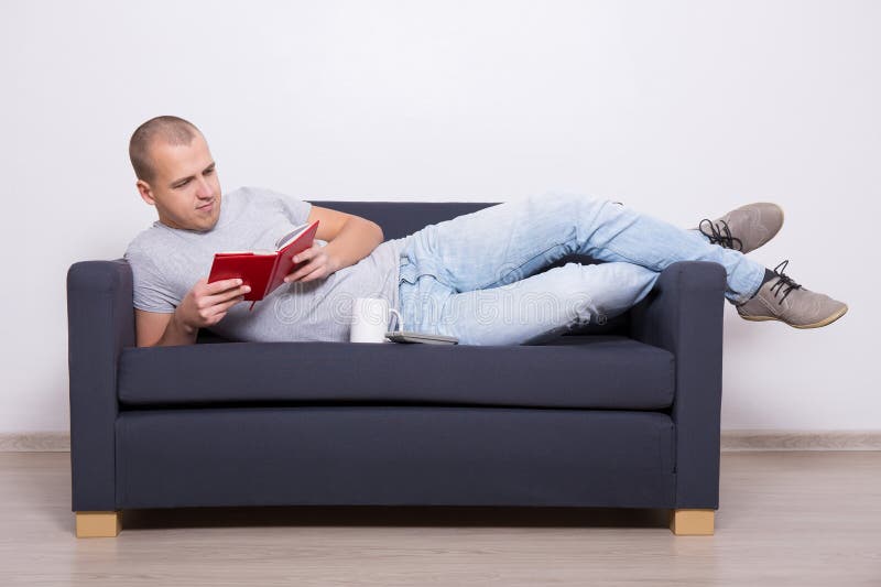 Handsome Man Lying on Sofa and Reading Book Stock Image - Image of ...