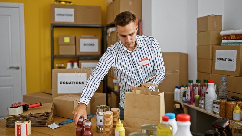 Handsome Man Packing Food in a Donation Center Warehouse Stock Image ...