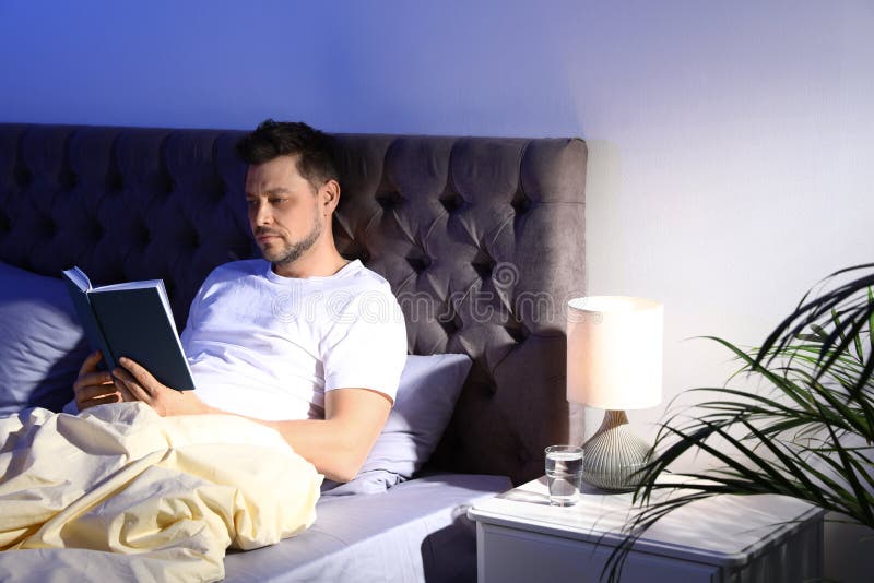 Handsome Man Reading Book in Dark Room at Night Stock Photo - Image of ...