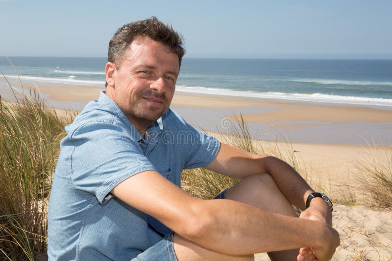 Handsome Man Relaxing on the Beach, Sitting on the Sand Stock Image ...
