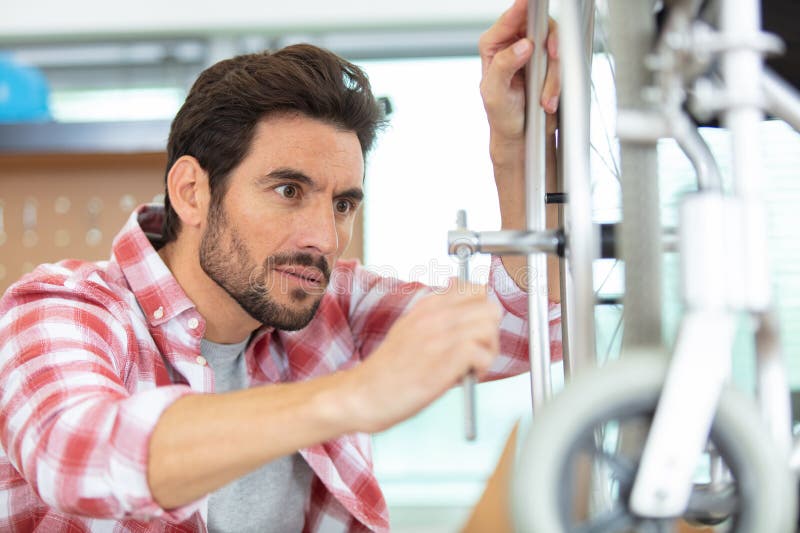 Handsome Man Repairing Wheelchair or Inspecting it Stock Image - Image ...
