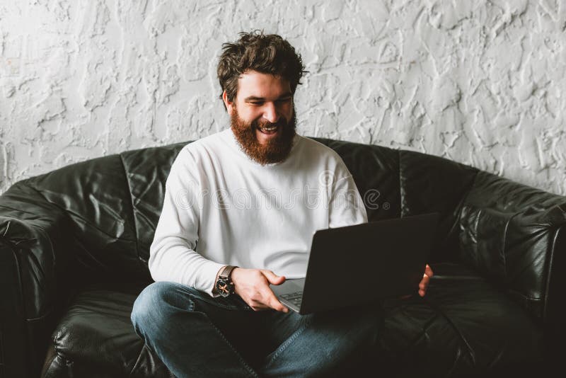 Handsome Man Sitting on Sofa and Working at Laptop Stock Image - Image ...