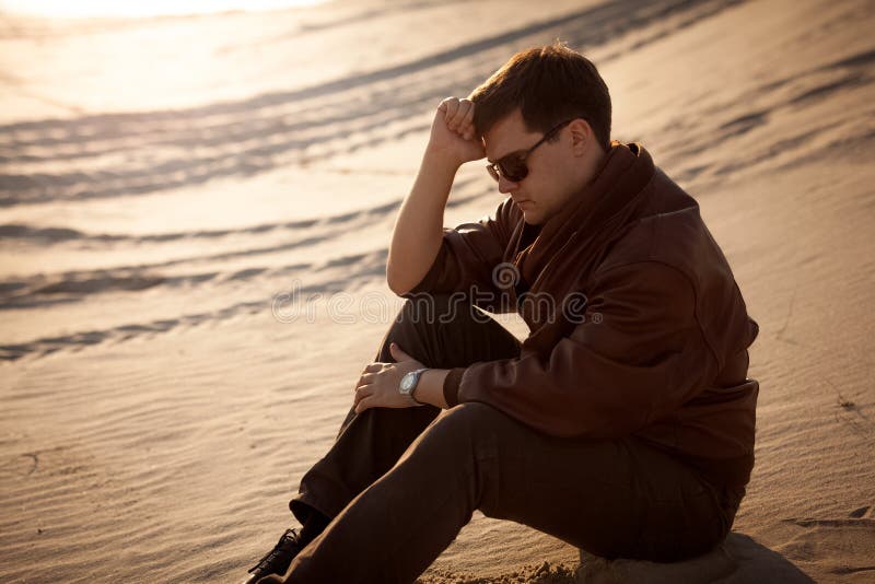 Handsome Man Sitting and Thinking on Sand Dune Stock Photo - Image of ...