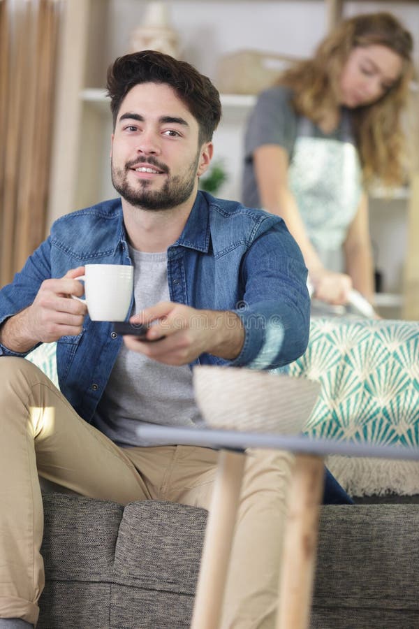 Handsome Man Sitting with Tv Remote Control while Wife Ironing Stock ...
