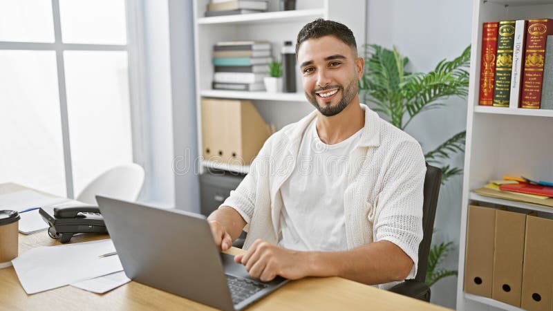 Handsome Man Smiling at Camera in Modern Office with Laptop, Papers ...