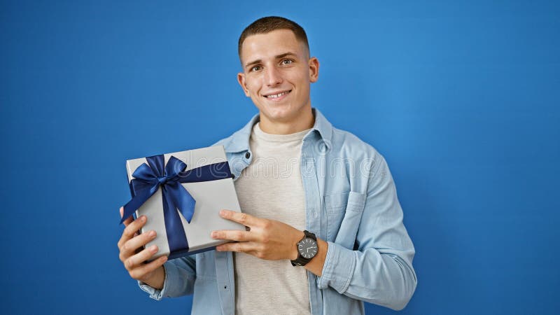 Handsome Man Smiling Holding Gift Isolated Against a Blue Backdrop ...