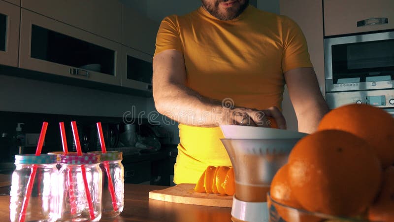 Handsome Man Squeezing Fresh Orange Juice with a Juicer Stock Photo ...