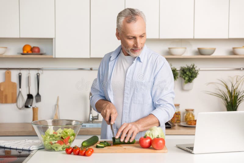 Handsome Man Standing at the Kitchen Using Laptop and Cooking Stock ...