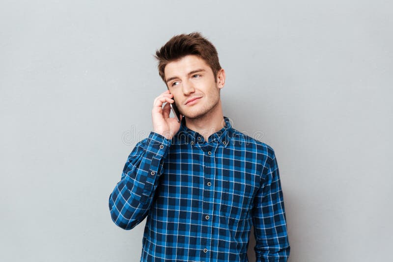 Handsome Man Standing Over Grey Wall and Talking by Phone. Stock Photo ...