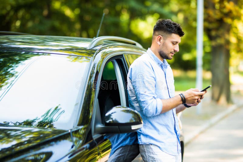 Handsome Young Man Standing and Using the Phone with His Car Stock ...