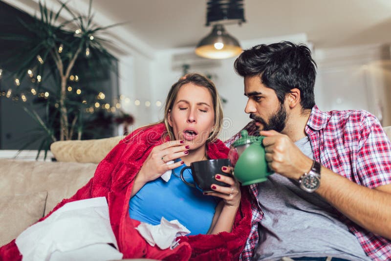 Man Taking Care of His Sick Girlfriend Lying on the Sofa Stock Photo ...