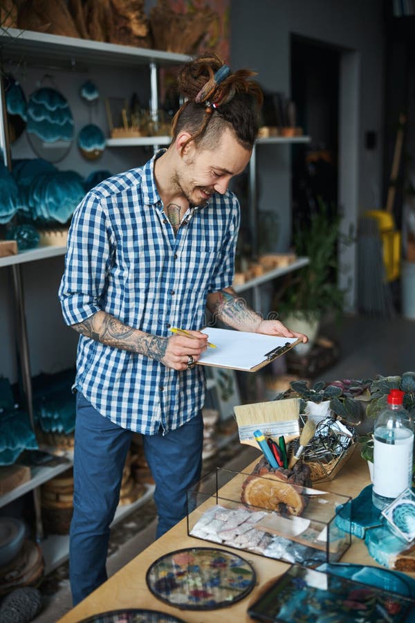 Cheerful Young Man Writing on Clipboard in Workshop Stock Image - Image ...