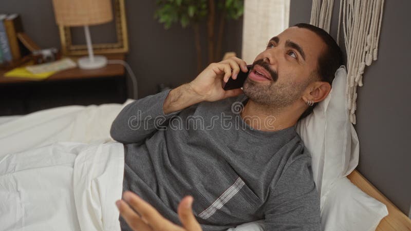 Handsome Man Talking on a Phone while Lying in Bed Inside a Cozy ...