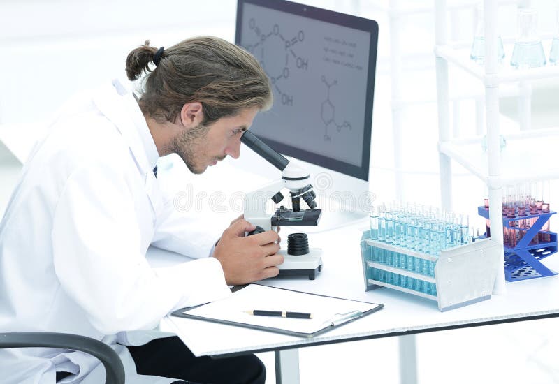 A Handsome Man Technician in the Lab Looking through Microscope Stock ...