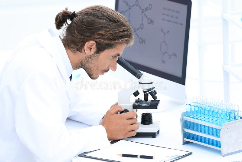 A Handsome Man Technician in the Lab Looking through Microscope Stock ...