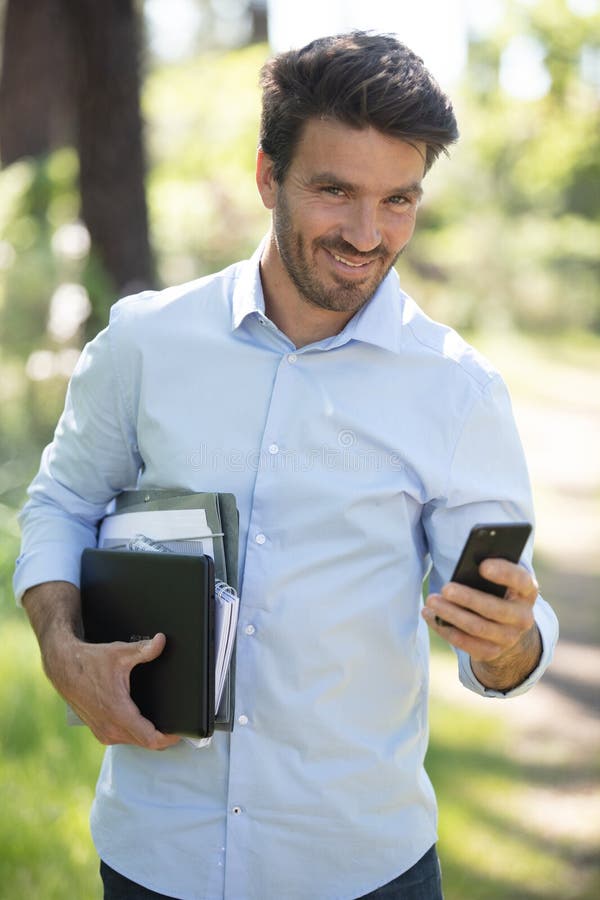 Handsome Man Texting on Cellphone while Holding Paper in Hand Stock ...