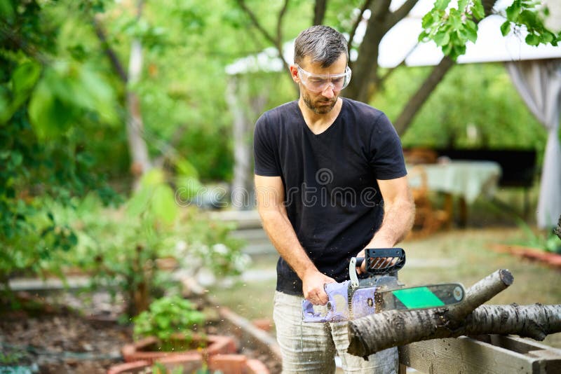Handsome Man Using Chainsaw for Cutting Tree Branches Stock Photo ...