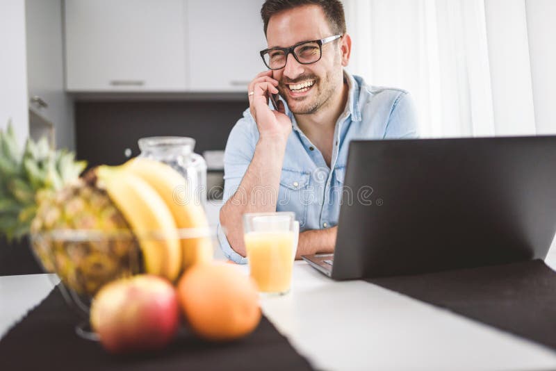 Handsome Man Using Laptop Computer at Home, Drinking Juice and Coffee ...