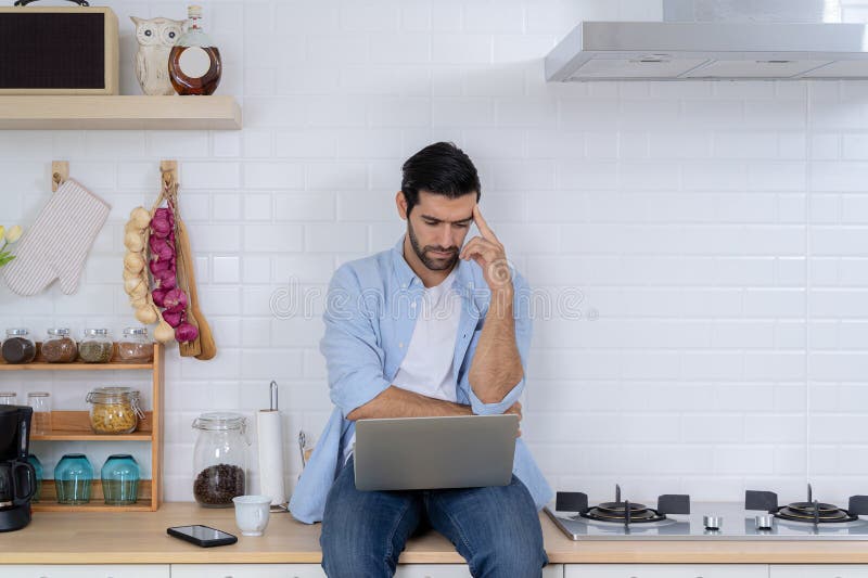 Handsome Man Using a Laptop Pc in the Kitchen, Concentrate and Thinking ...