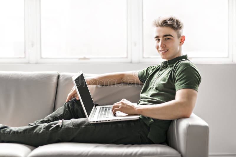 Handsome Man Using a Laptop Sitting on Couch at Home Stock Photo ...