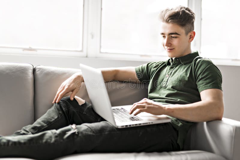 Handsome Man Using a Laptop Sitting on Couch at Home Stock Photo ...